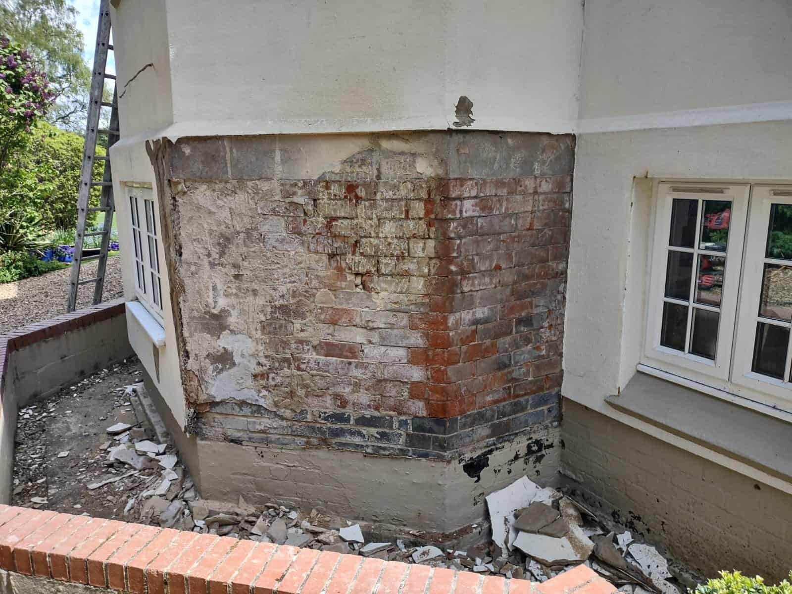 Repairing render and painting the walls of this former mill